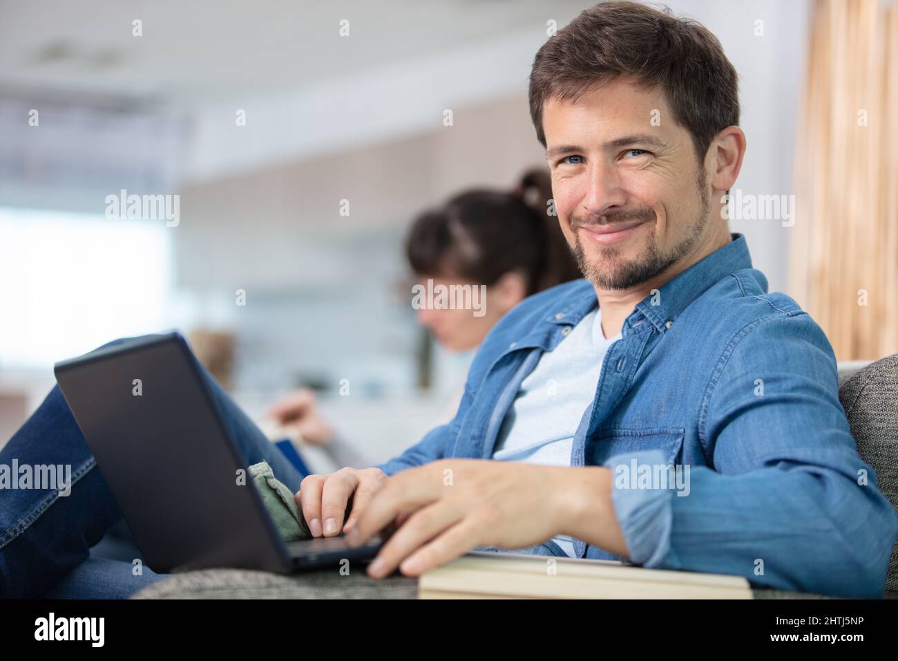 young attractive smiling guy is browsing on his laptop Stock Photo - Alamy