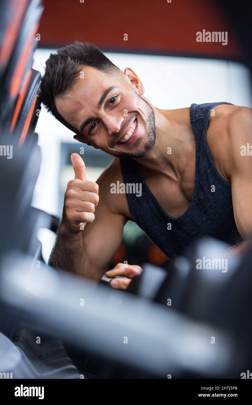 handsome young man lifting weight smiling and showing thumbs up Stock ...