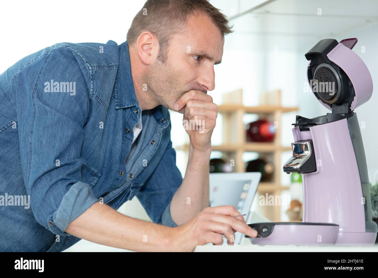 man trying to understand how to use coffee machine Stock Photo - Alamy