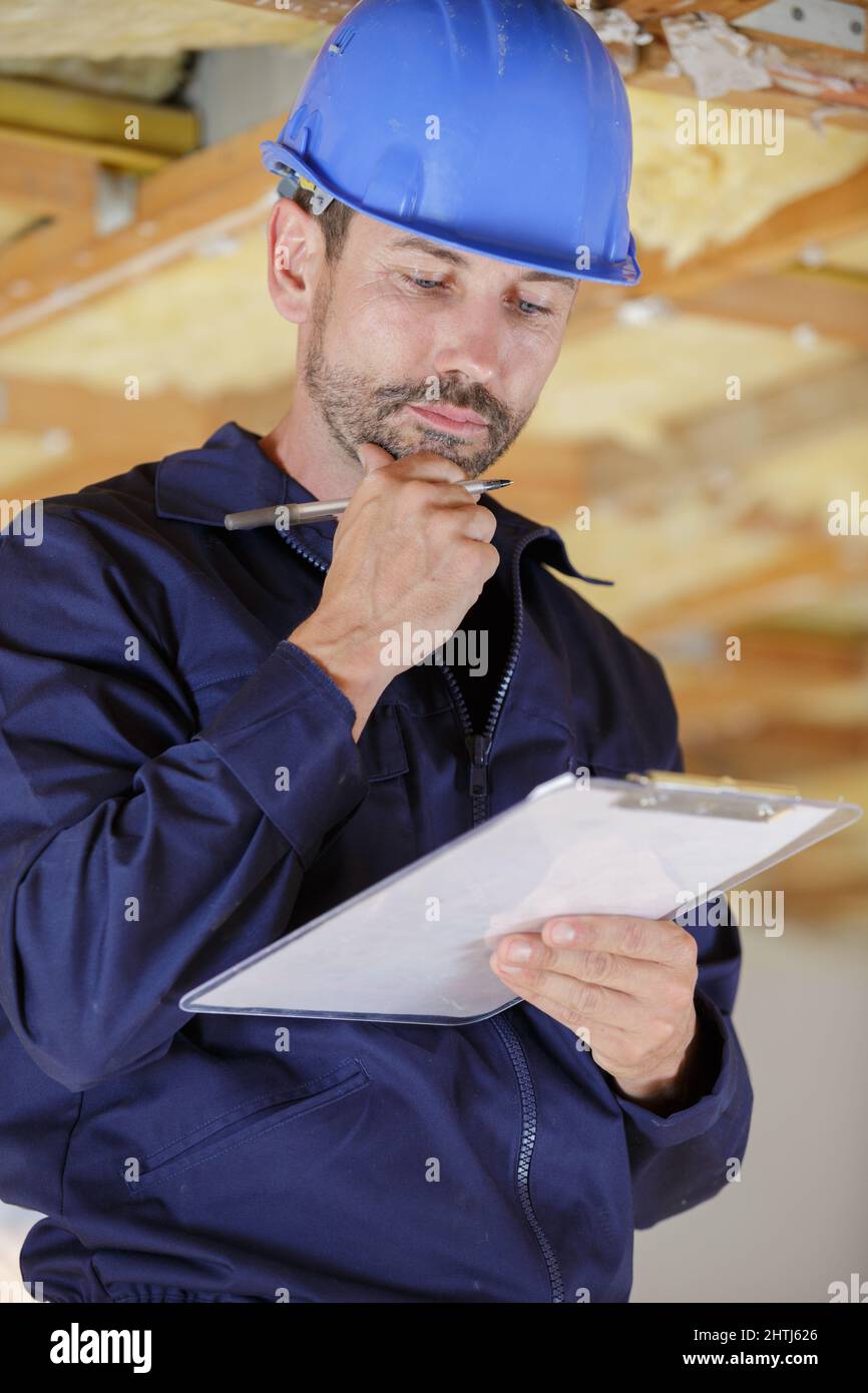male builder in yellow hard hat with clipboard Stock Photo - Alamy