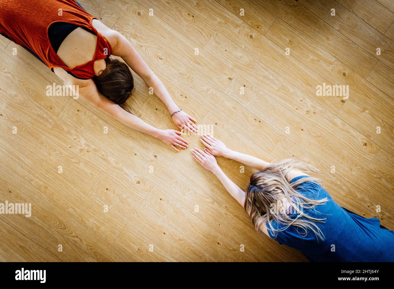 Top view of two young female laying in a face down yoga position on a ...