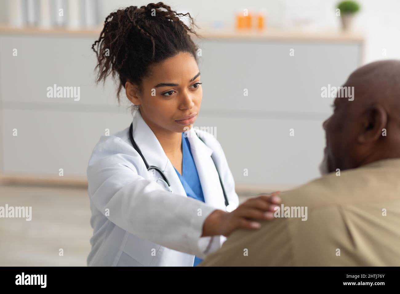 Close up of black female doctor tapping patting patient's shoulder ...