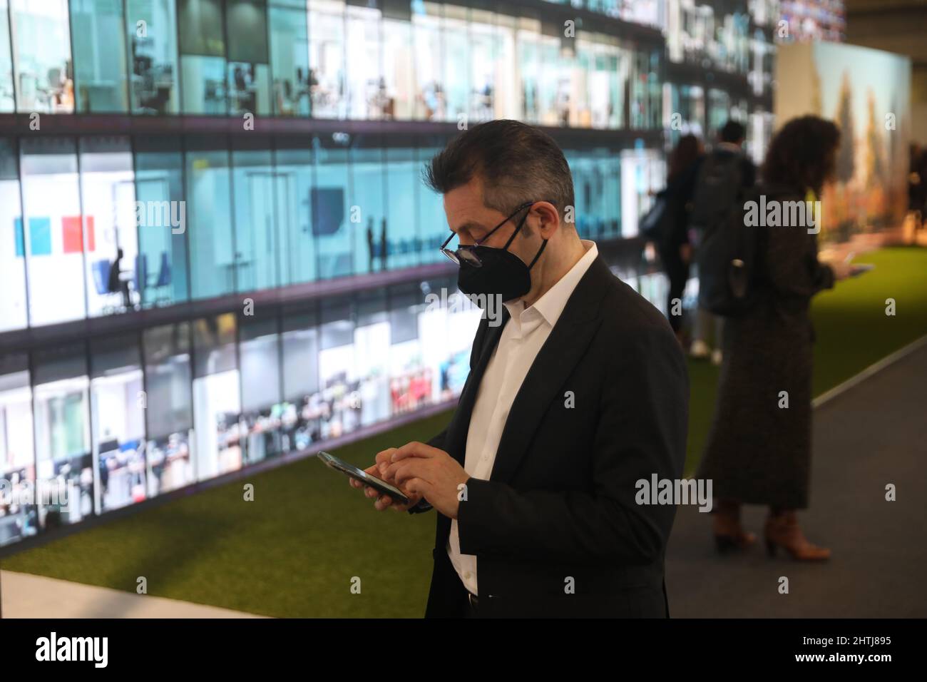 Barcelona, Spain. 28th Feb, 2022. A visitor looks at his phone in front ...