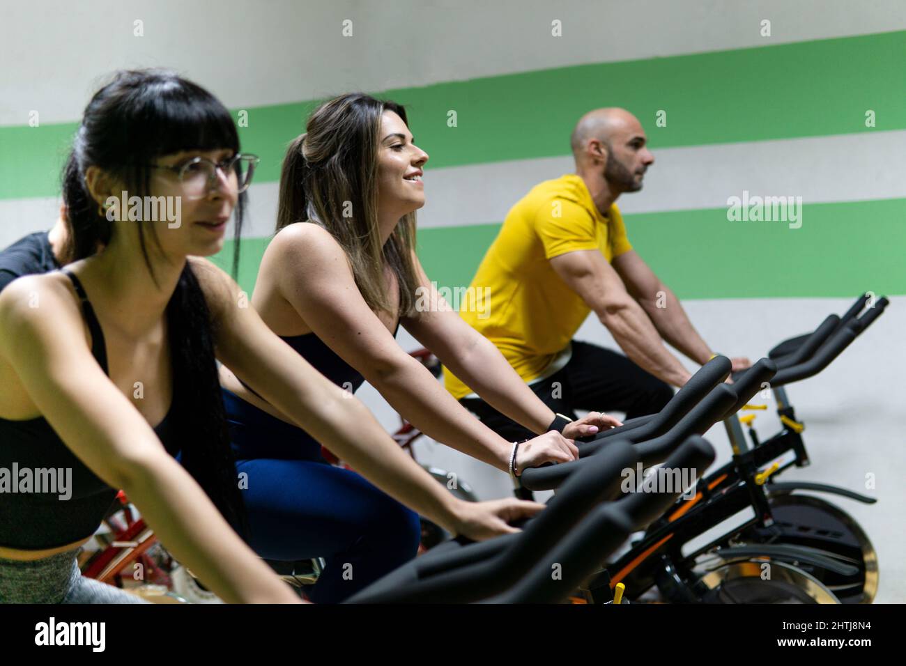 Group of friends doing static bicycle in the gym. Healthy lifestyle ...