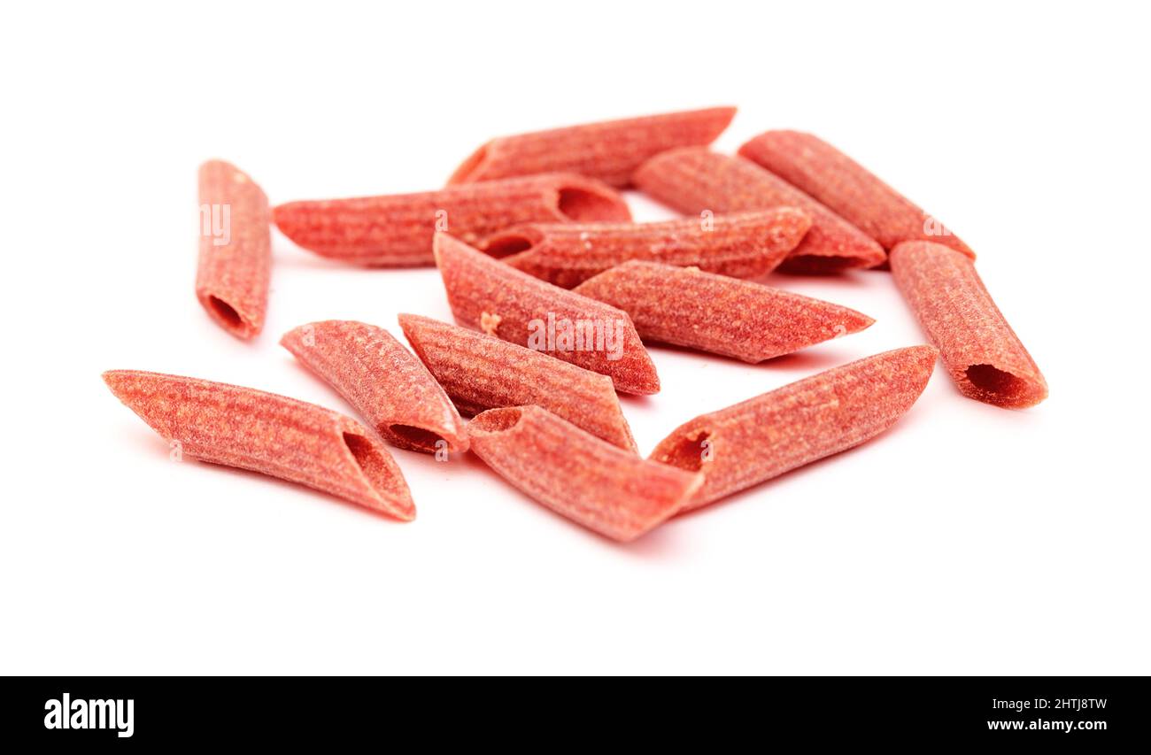 Dry Penne pasta with natural red beetroot coloring isolated on white ...