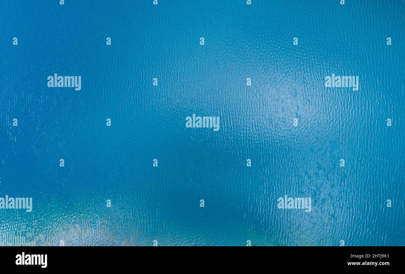 Aerial view of a blue sea surface water texture background and sun ...