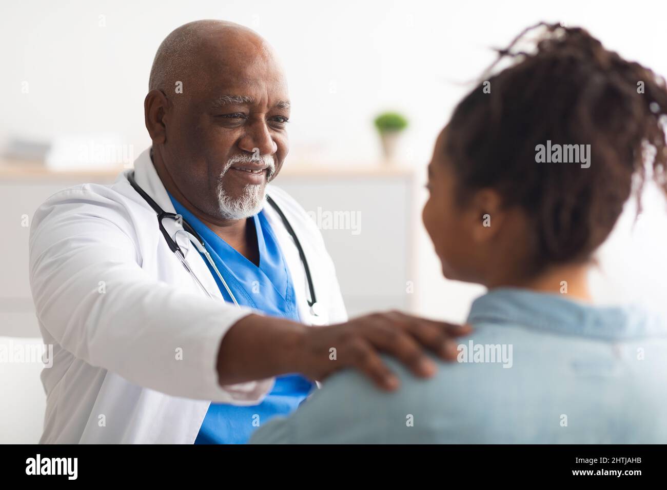 Close up of black male doctor tapping patting patient's shoulder Stock ...