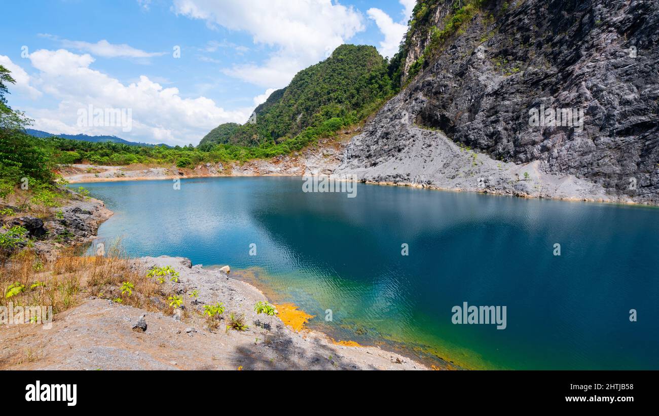 Amazing pond in tropical rainforest forest with mountain rocks peak ...