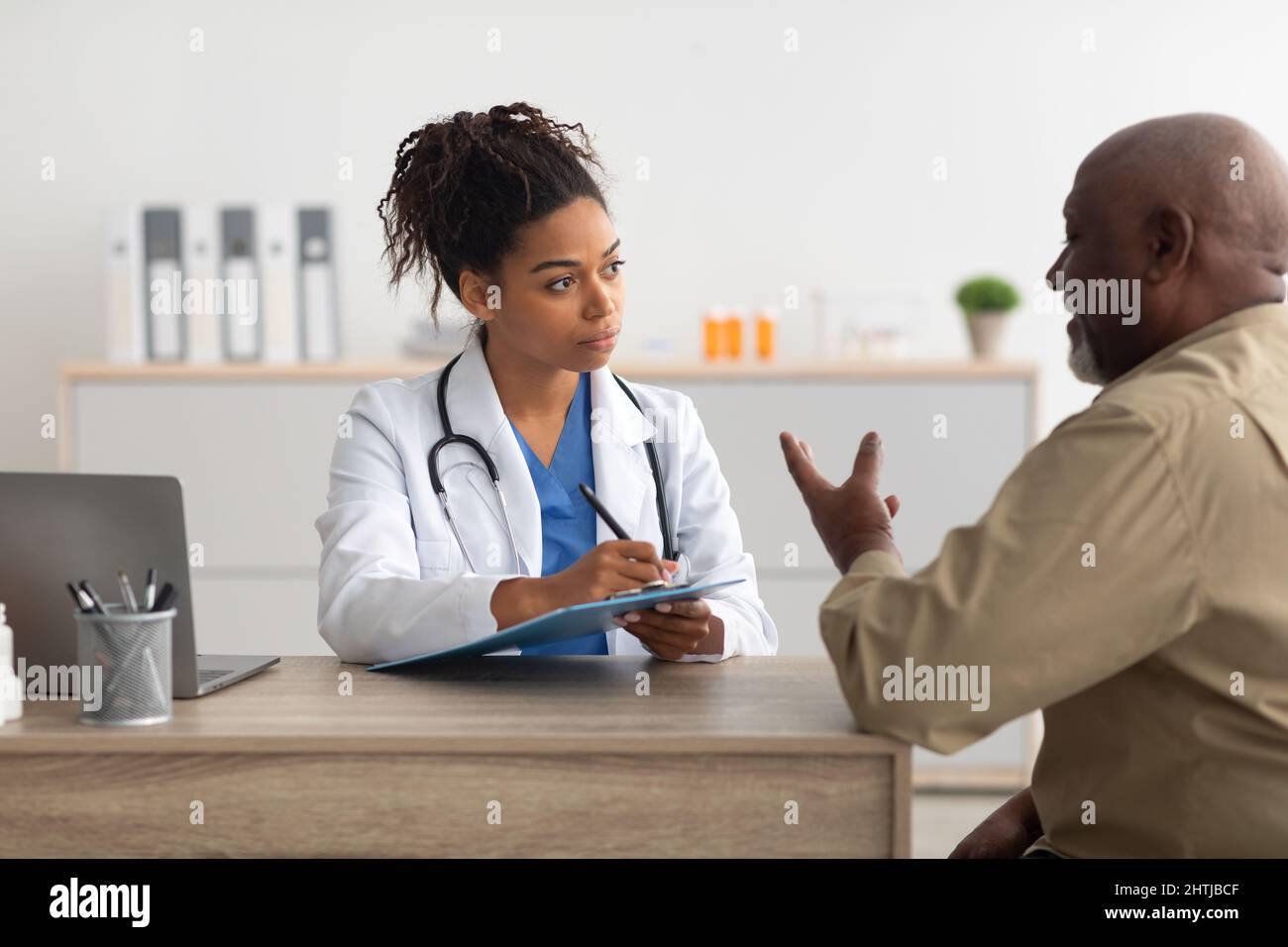 Young black doctor explaining treatment plan to male patient Stock ...