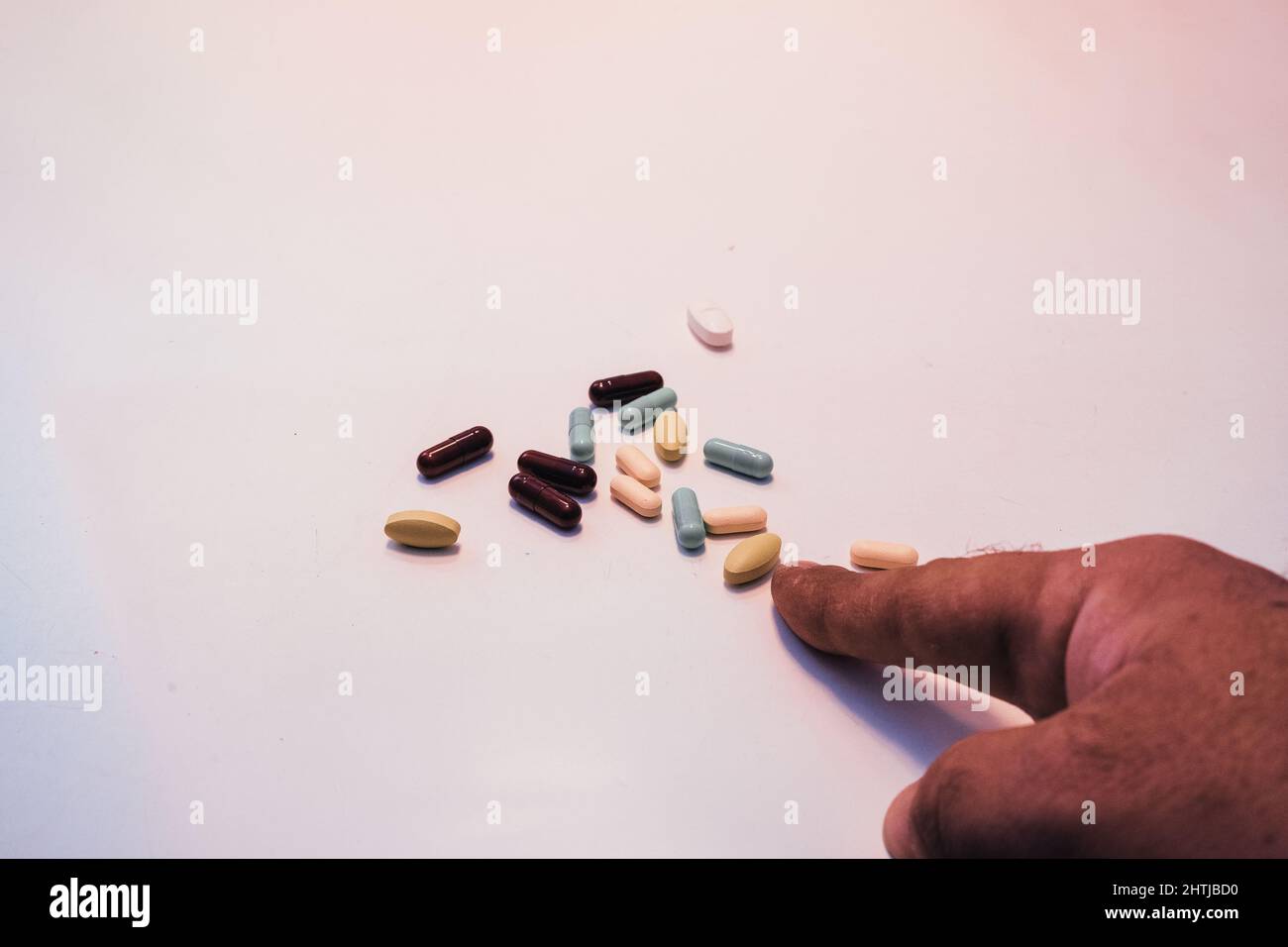 finger pointing loose pills on the table Stock Photo - Alamy