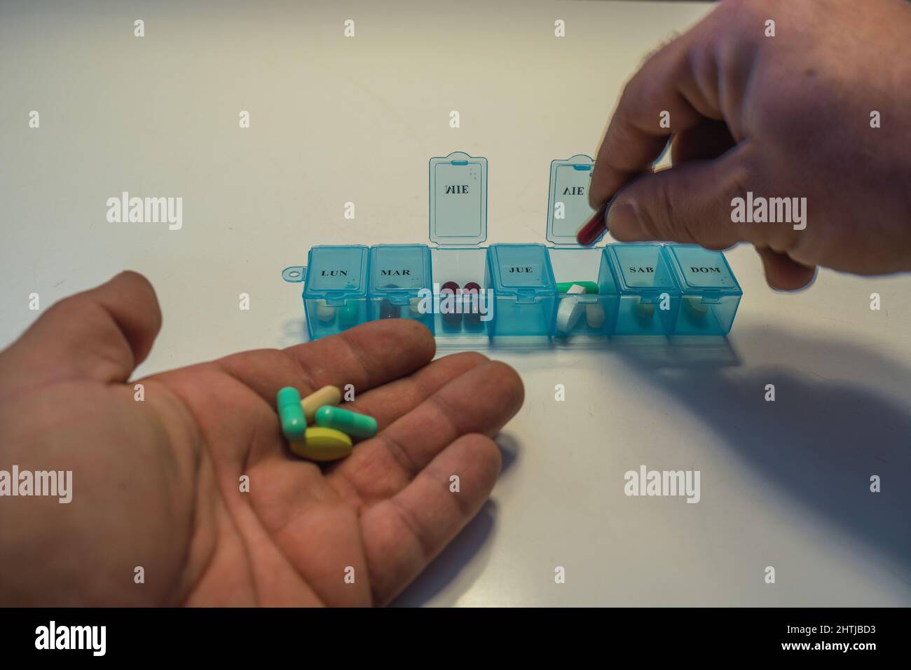 Senior man organizing his medication in pill dispenser Stock Photo - Alamy