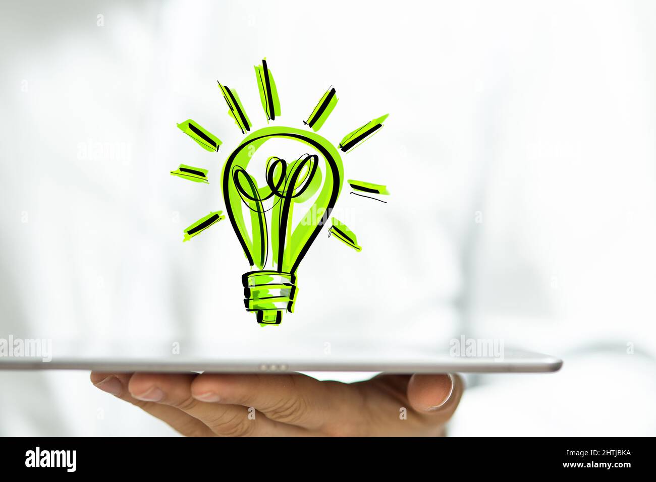 Hand holding a tablet and some illustrates a lightbulb sign over the ...