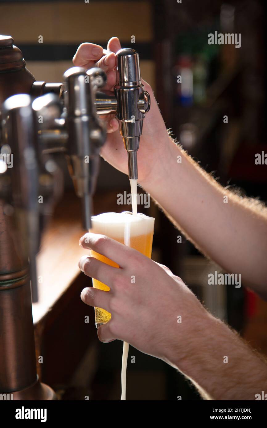 Side view of cropped unrecognizable male barkeeper with red hair ...