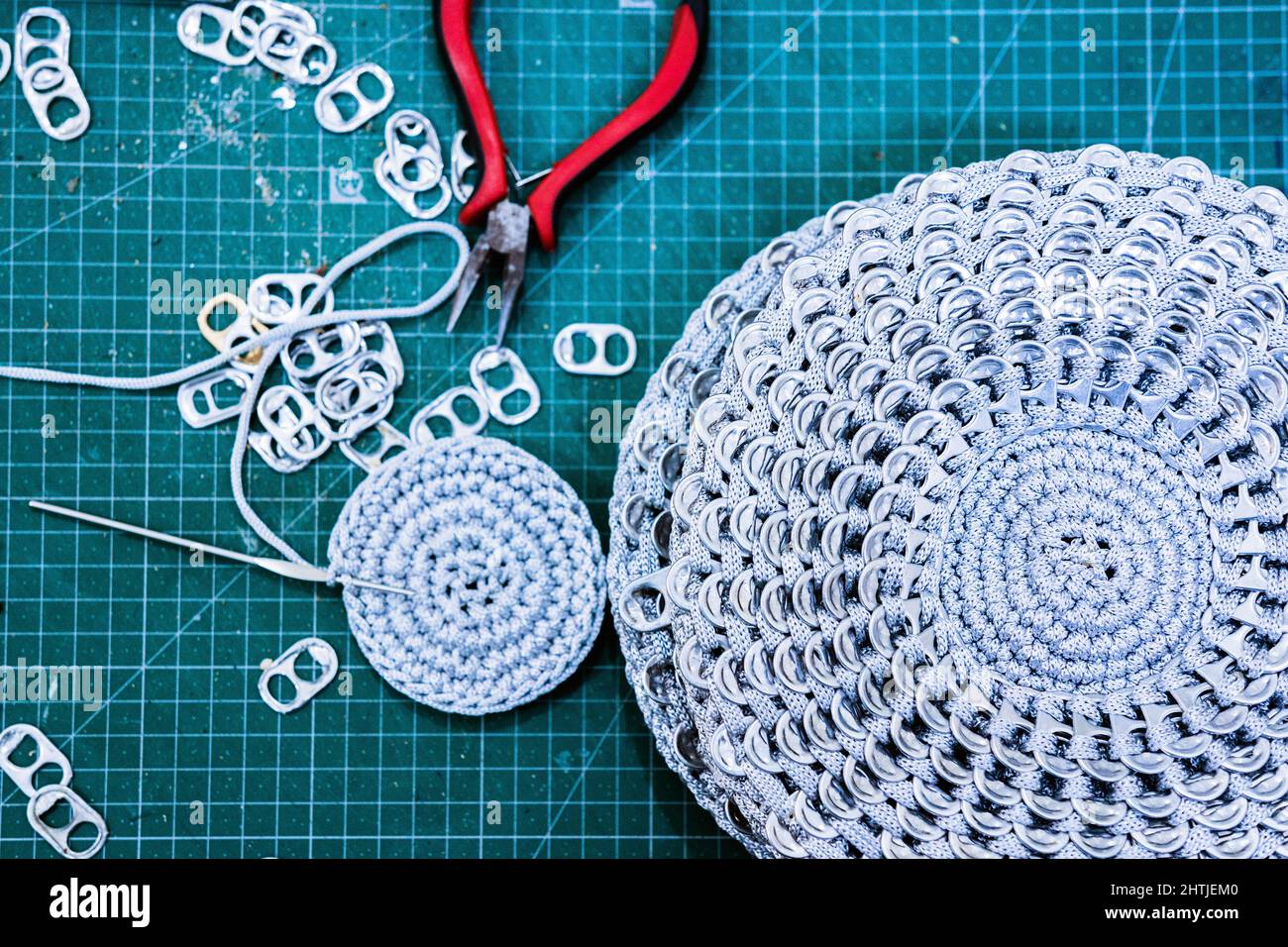 Top view of handmade crochet napkin made out of aluminium ring pulls ...
