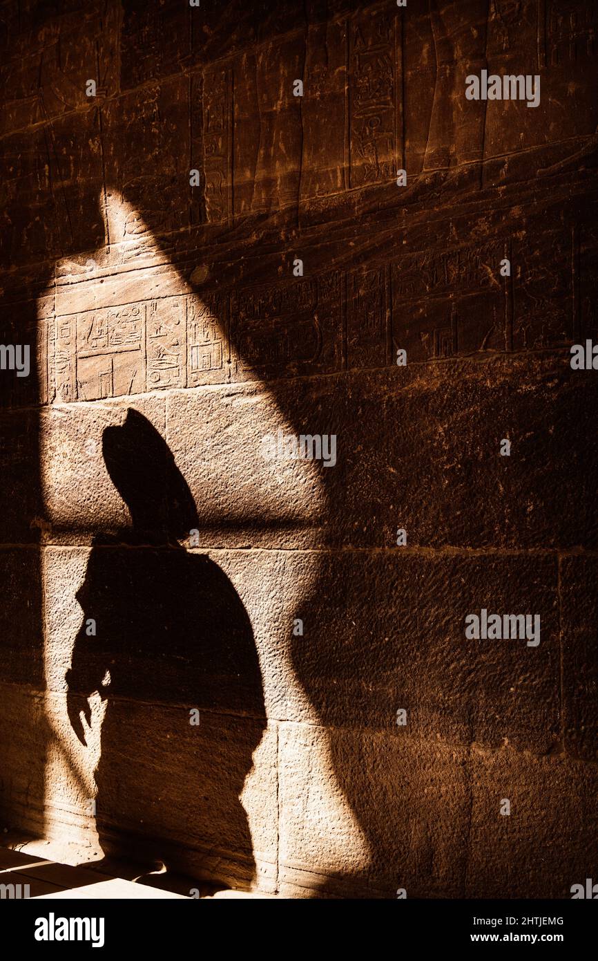 Shadow of anonymous traveler standing near ancient wall with ...