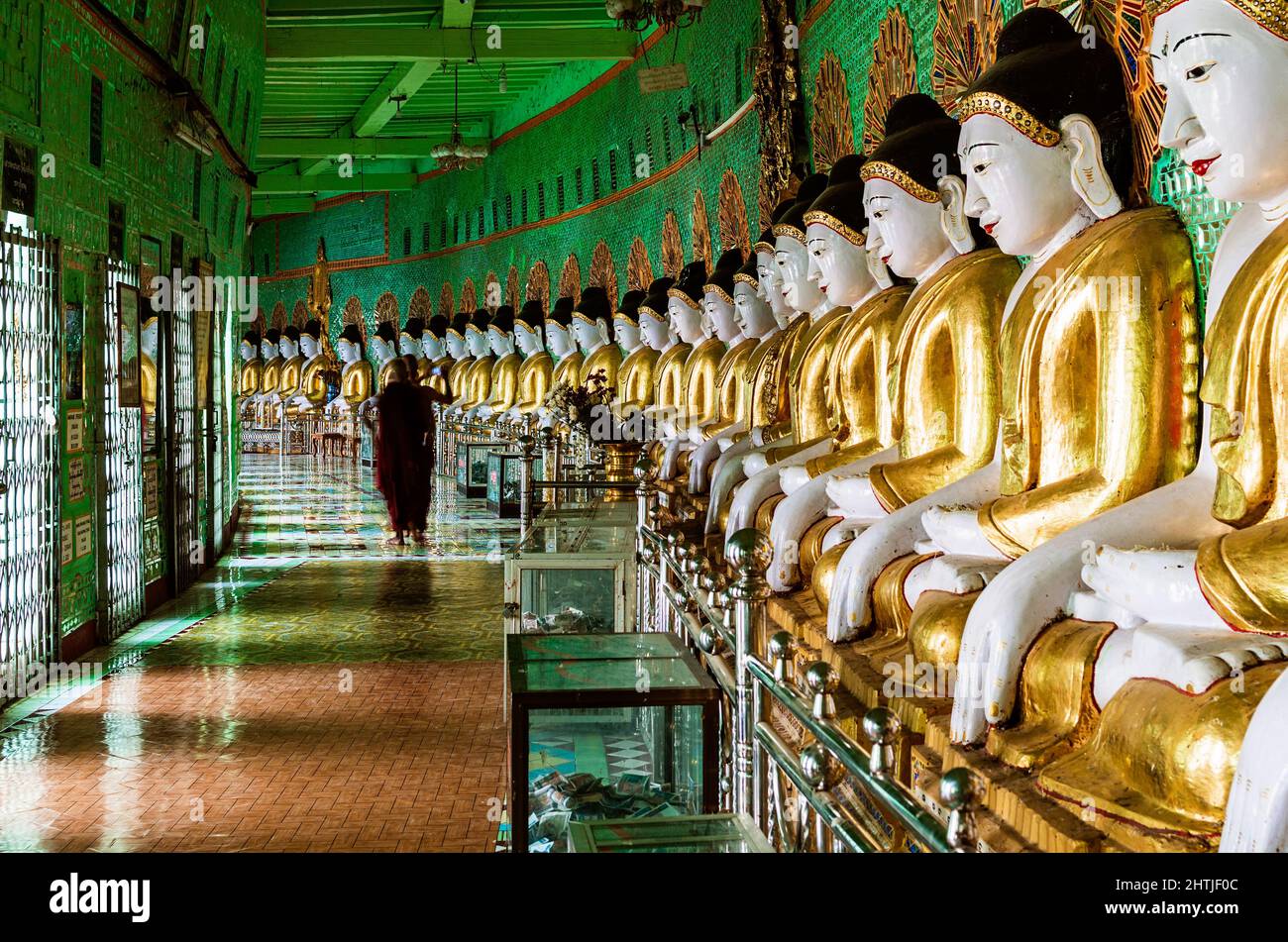 Traditional ancient statues of Buddhas placed in row at wall in ...