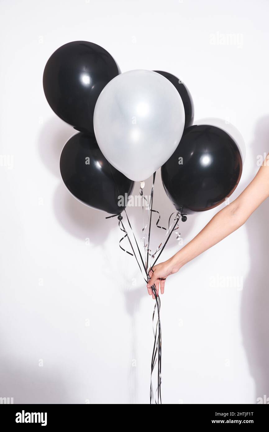 Cropped unrecognizable female arms holding bunch of balloons in hand ...