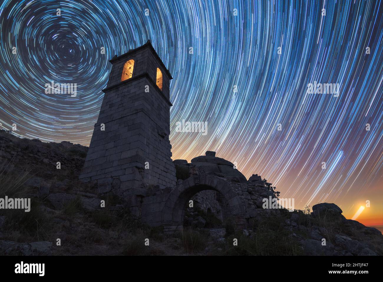 From below of aged stone tower with glowing lights located against ...