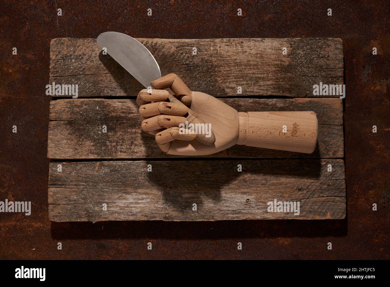 Top view of wooden mannequin hand with knife placed on shabby chopping ...