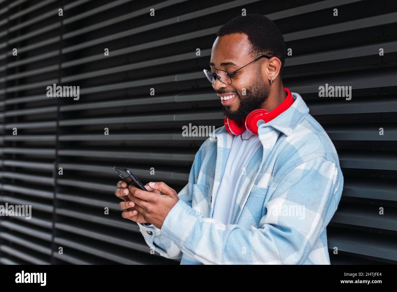 Happy African American male with cellphone listening to music in ...