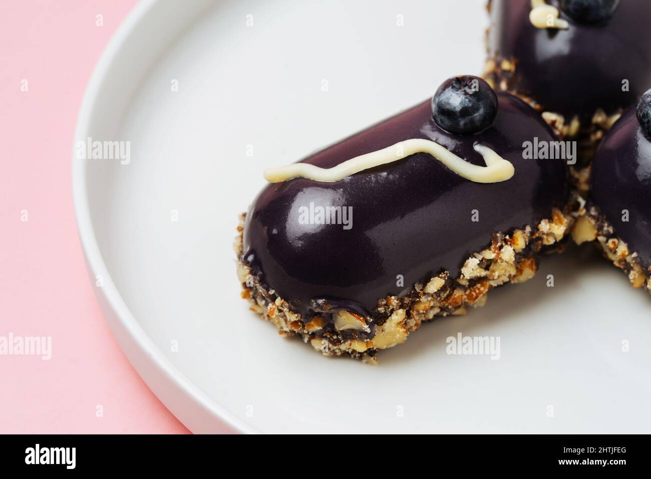 Tasty sweet purple pastries decorated with blueberries and chopped nuts ...
