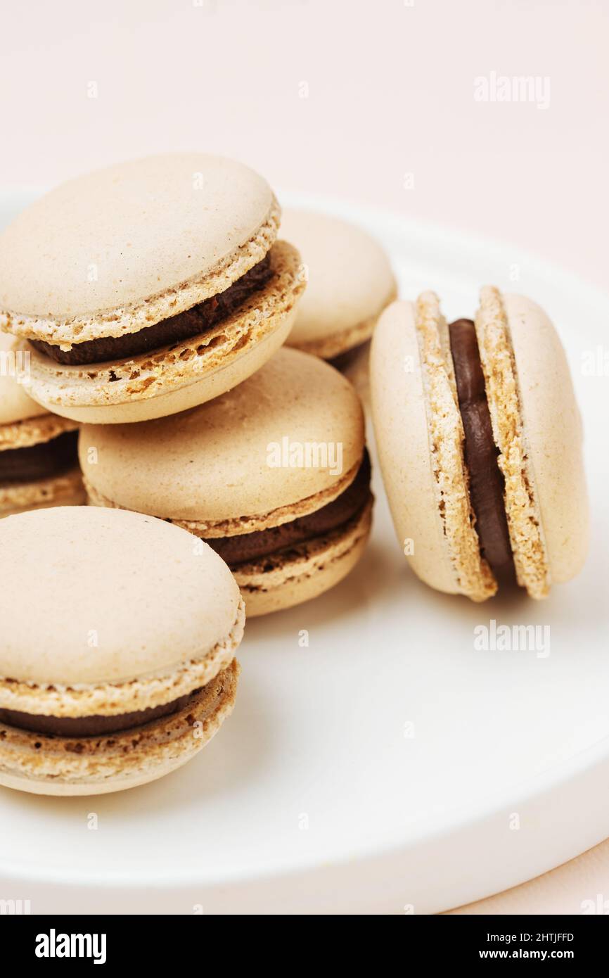 Pile of coffee flavored macaroons with sweet filling served on white ...