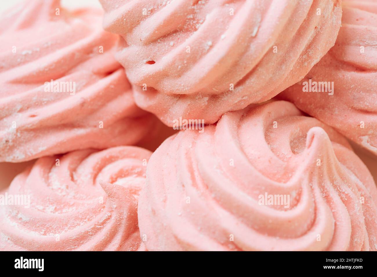 Close-up pile of fresh tasty pink zefir with ridged textured surface ...