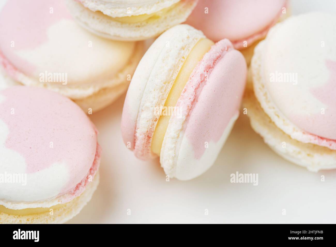 Heap of sweet round pink and white macaroons with filling served on ...