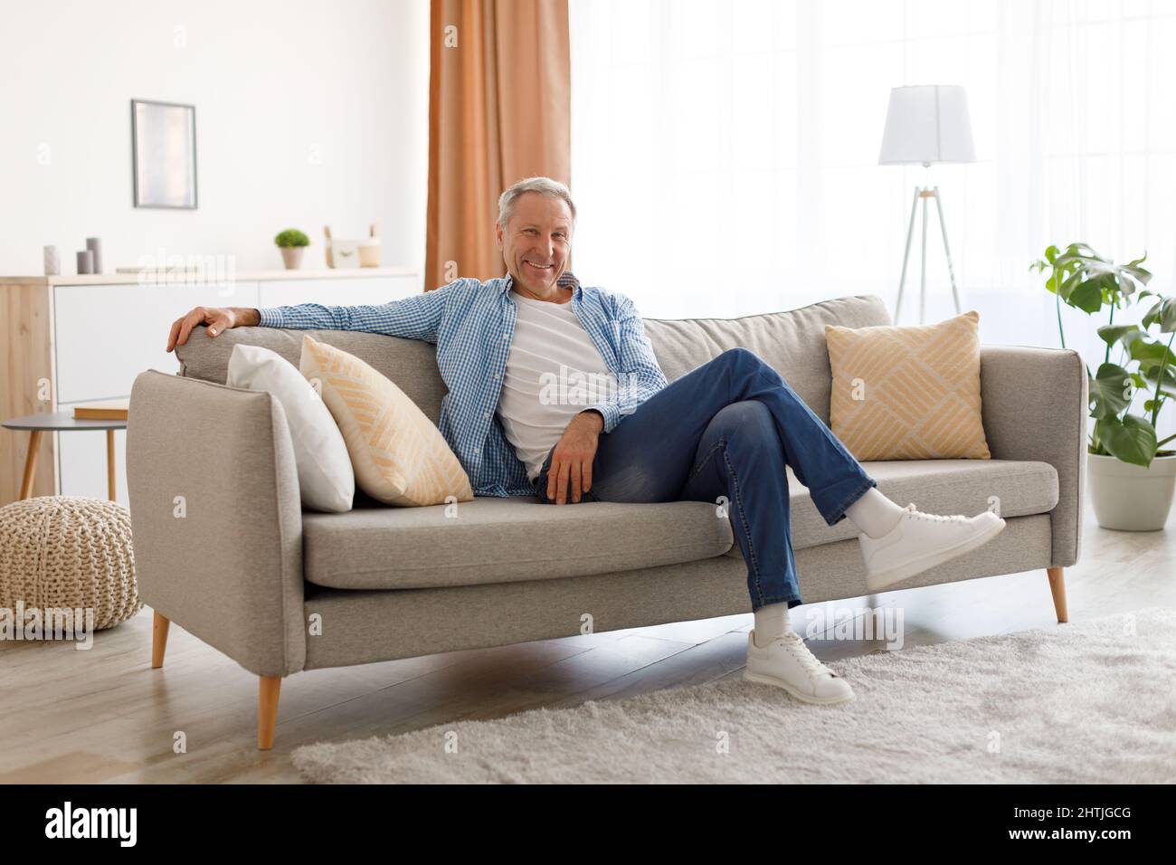 Mature man having rest at home on the couch Stock Photo - Alamy
