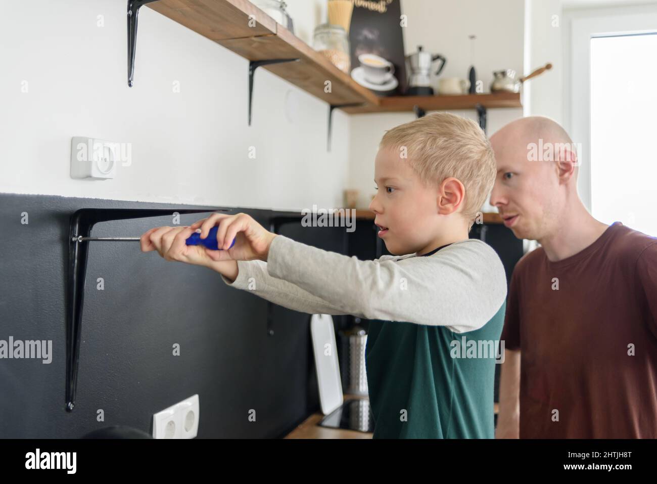 Father and son doing house renovations together. Using screwdriver. Dad ...