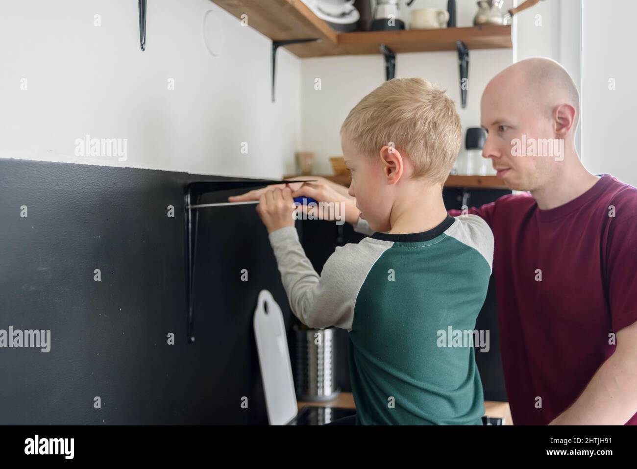 Father and son doing house renovations together. Using screwdriver. Dad ...