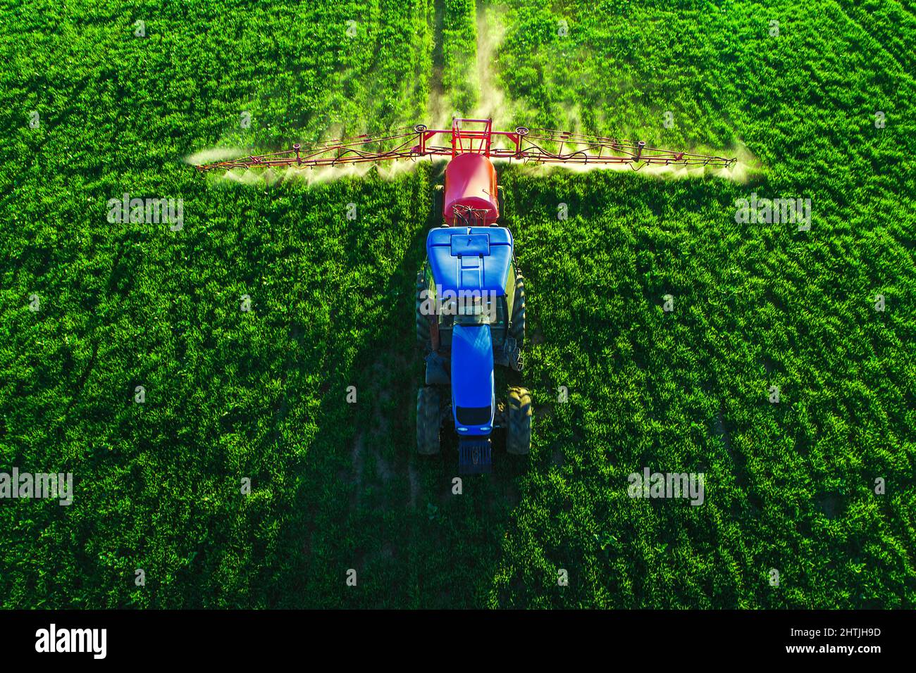 Aerial view of farming tractor plowing and spraying on field Stock ...