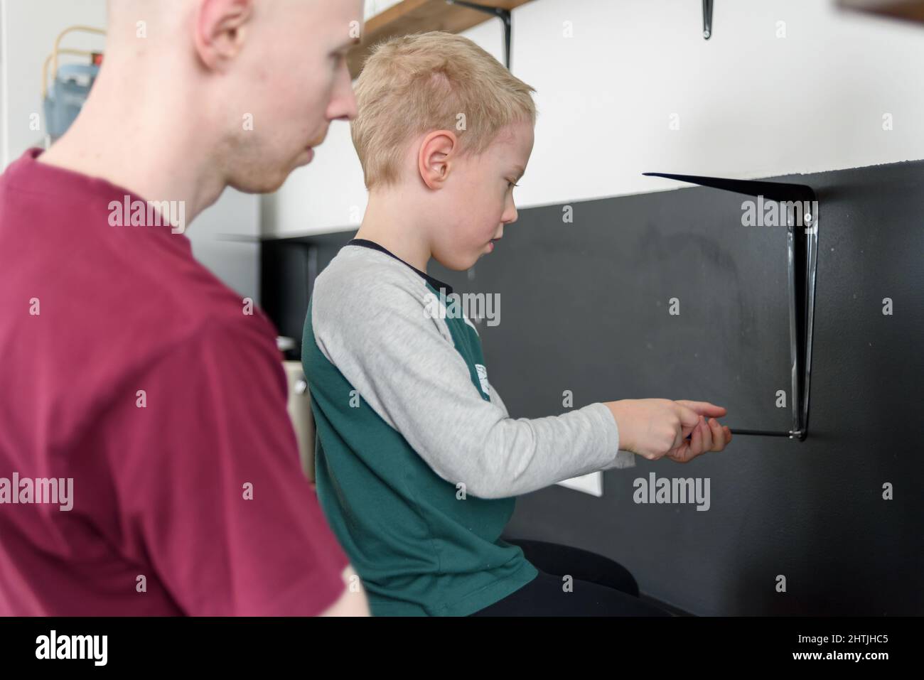 Father and son doing house renovations together. Using screwdriver. Dad ...