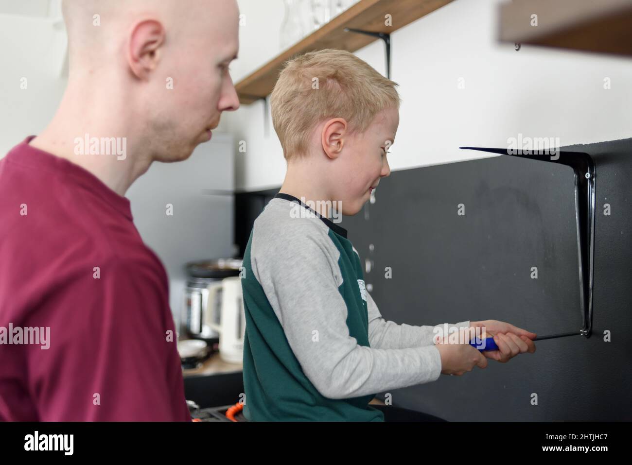 Father and son doing house renovations together. Using screwdriver. Dad ...