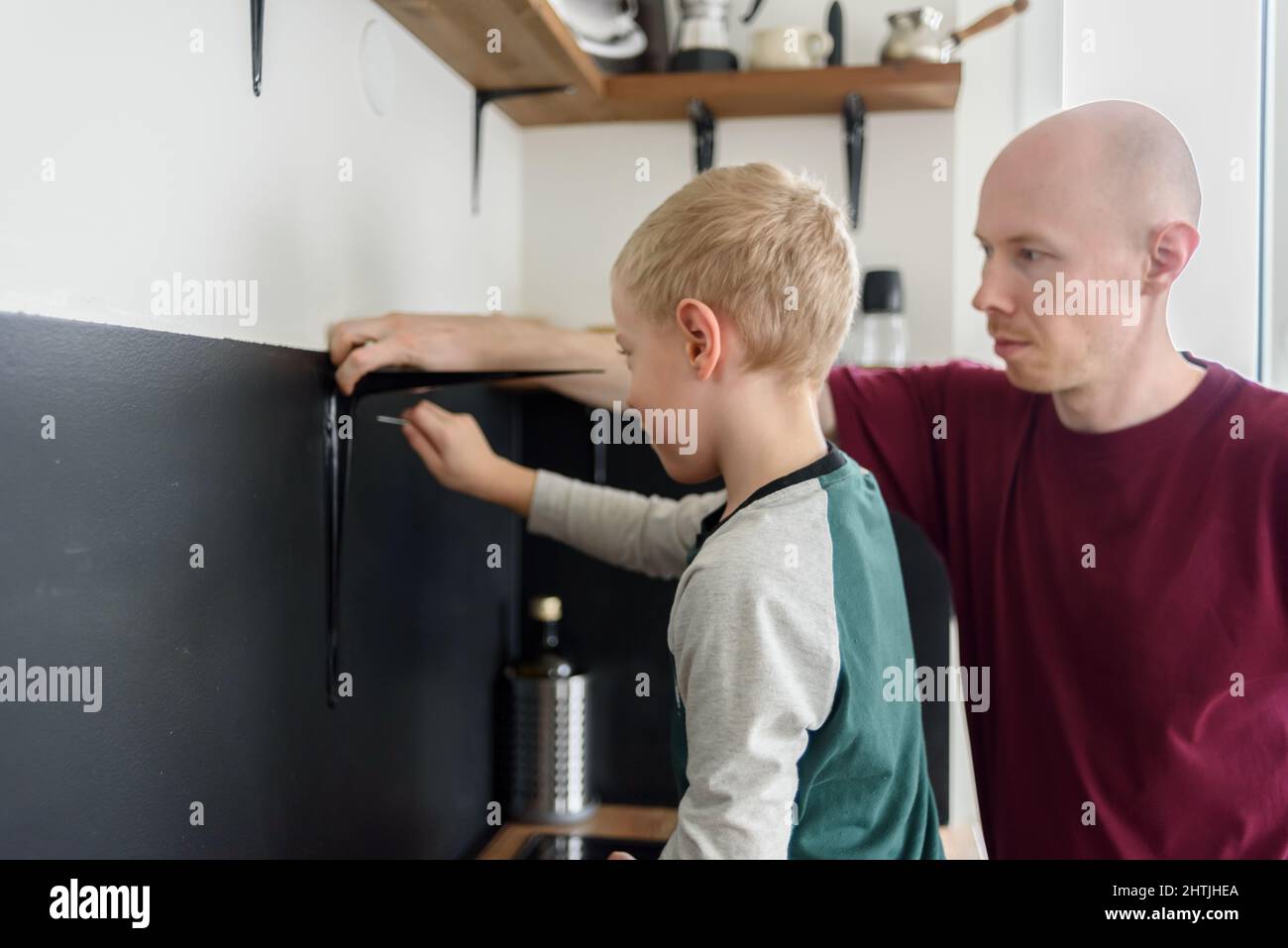 Father and son doing house renovations together. Using screwdriver. Dad ...