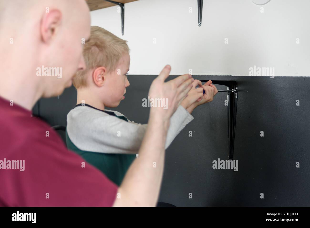 Father and son doing house renovations together. Using screwdriver. Dad ...