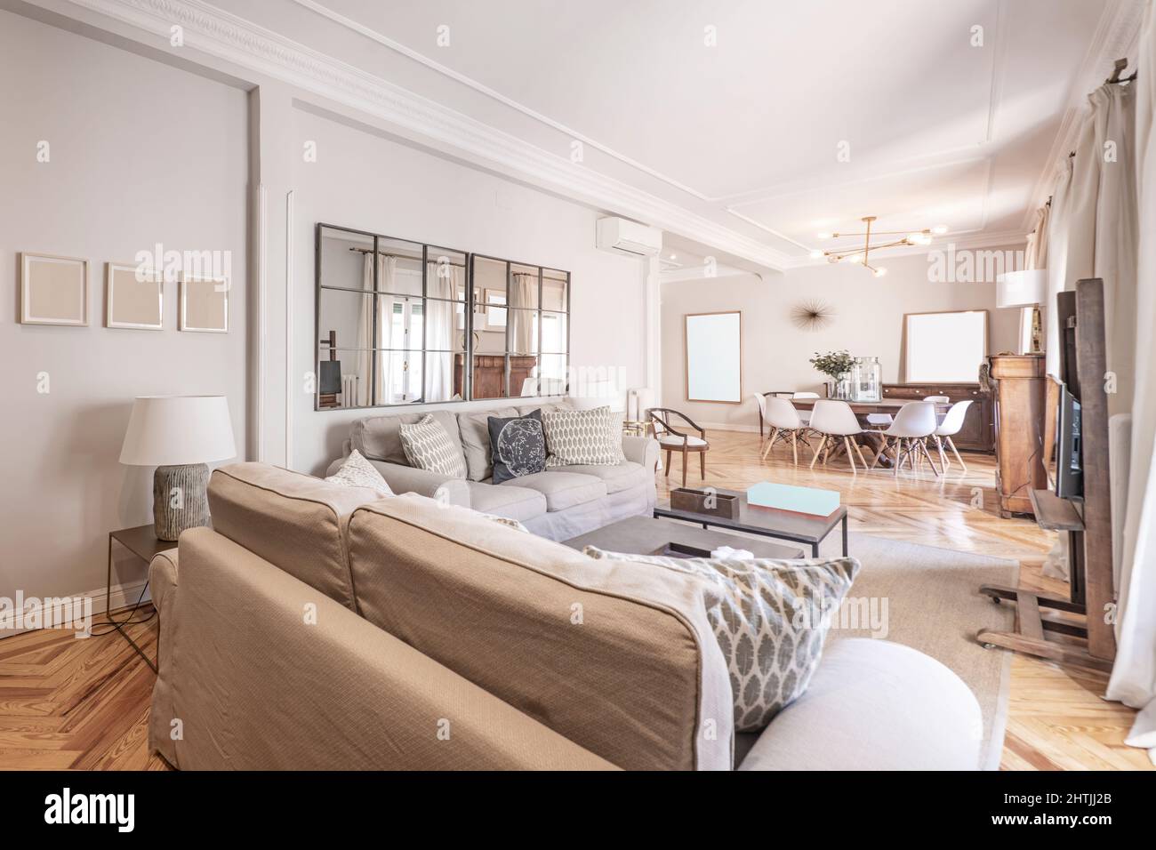 Living room with large sofas, wall covered with square mirrors, square ...