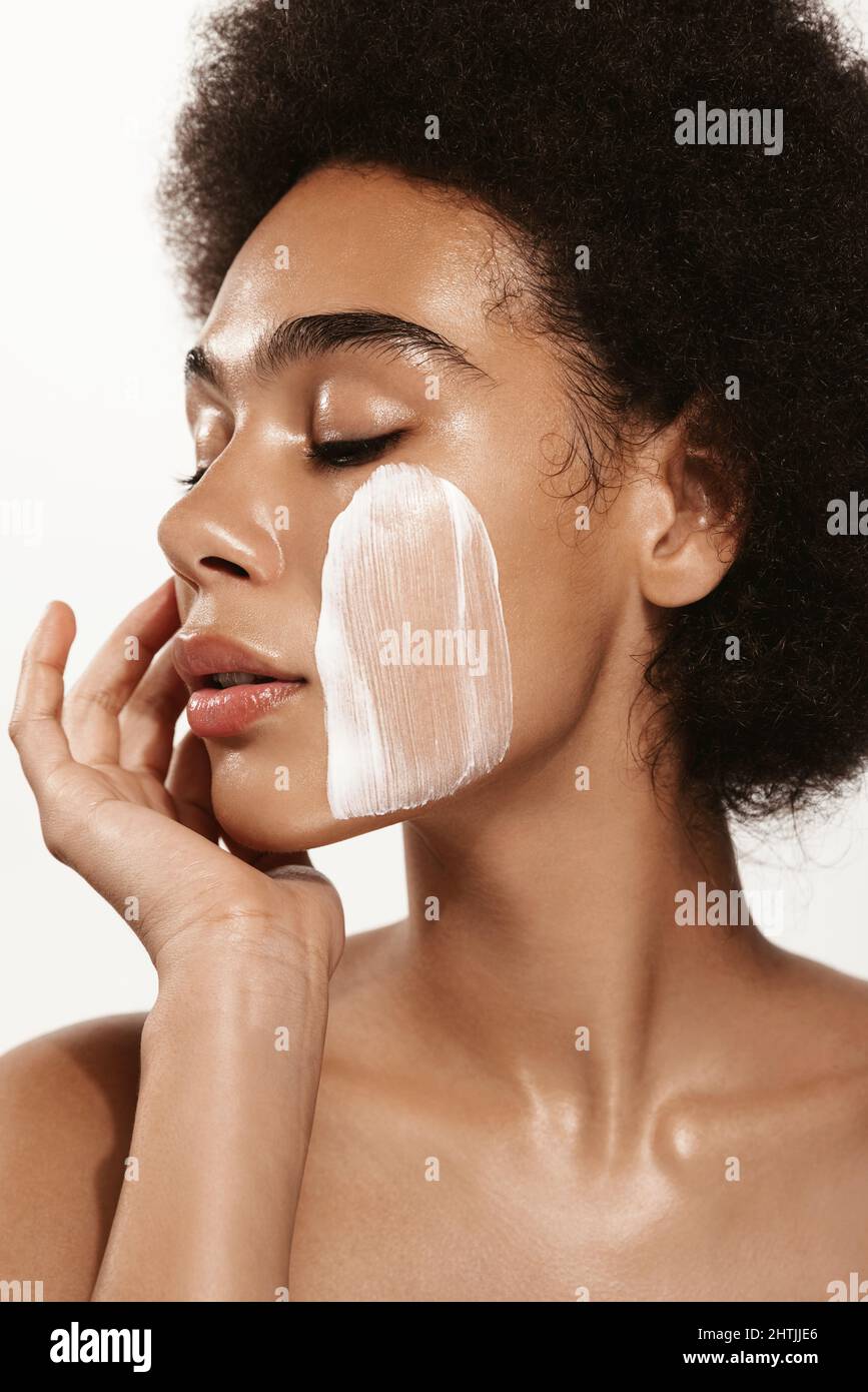 Vertical Portrait Of Sensual Black Woman Gently Touching Her Soft Healthy Face With Facial
