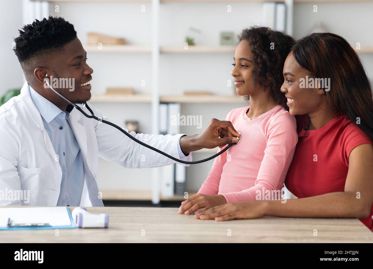 Black mother and daughter having checkup at pediatrician Stock Photo ...