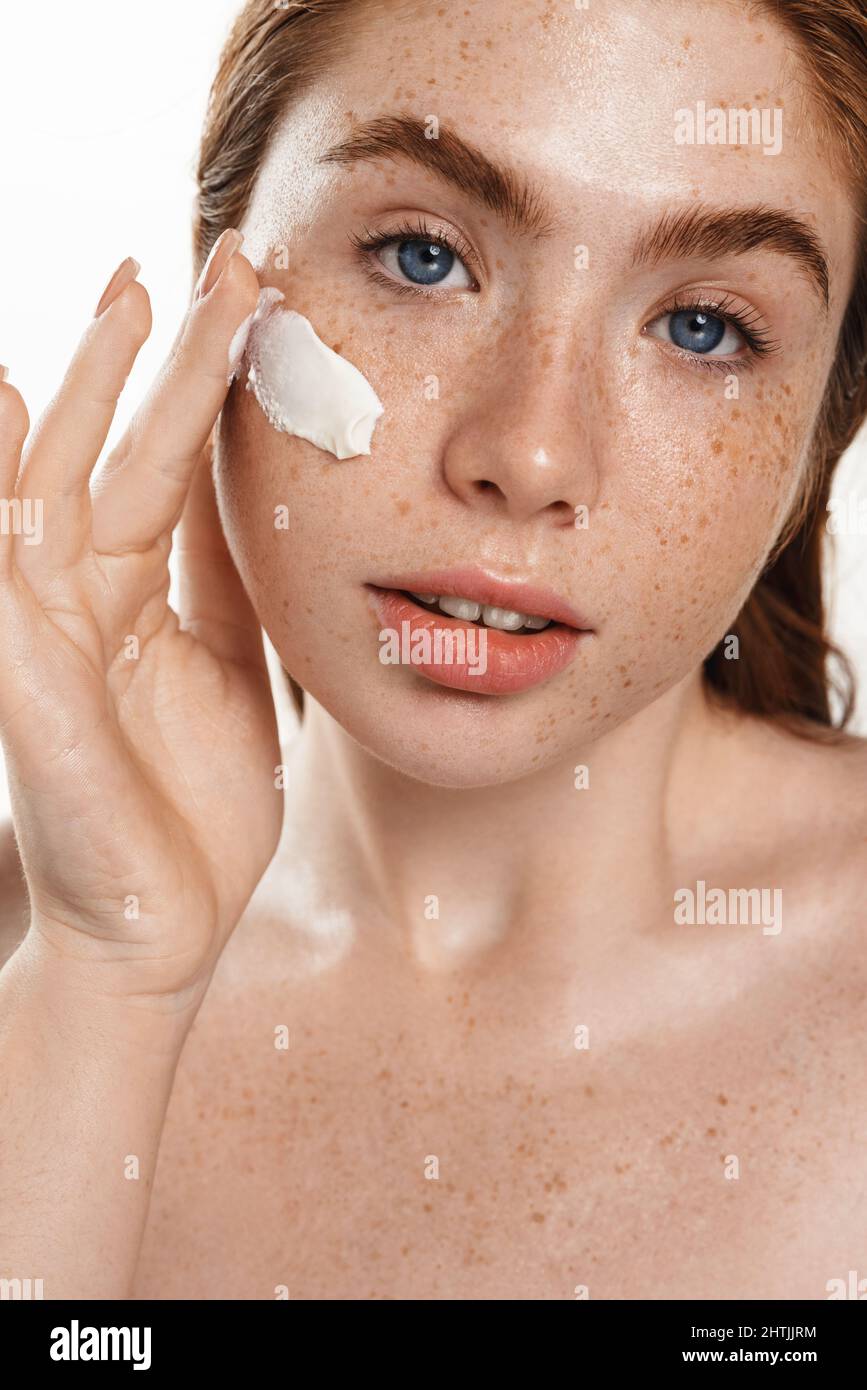 Face skin care. Plus size woman, apply cosmetic cream on clean hydrated ...