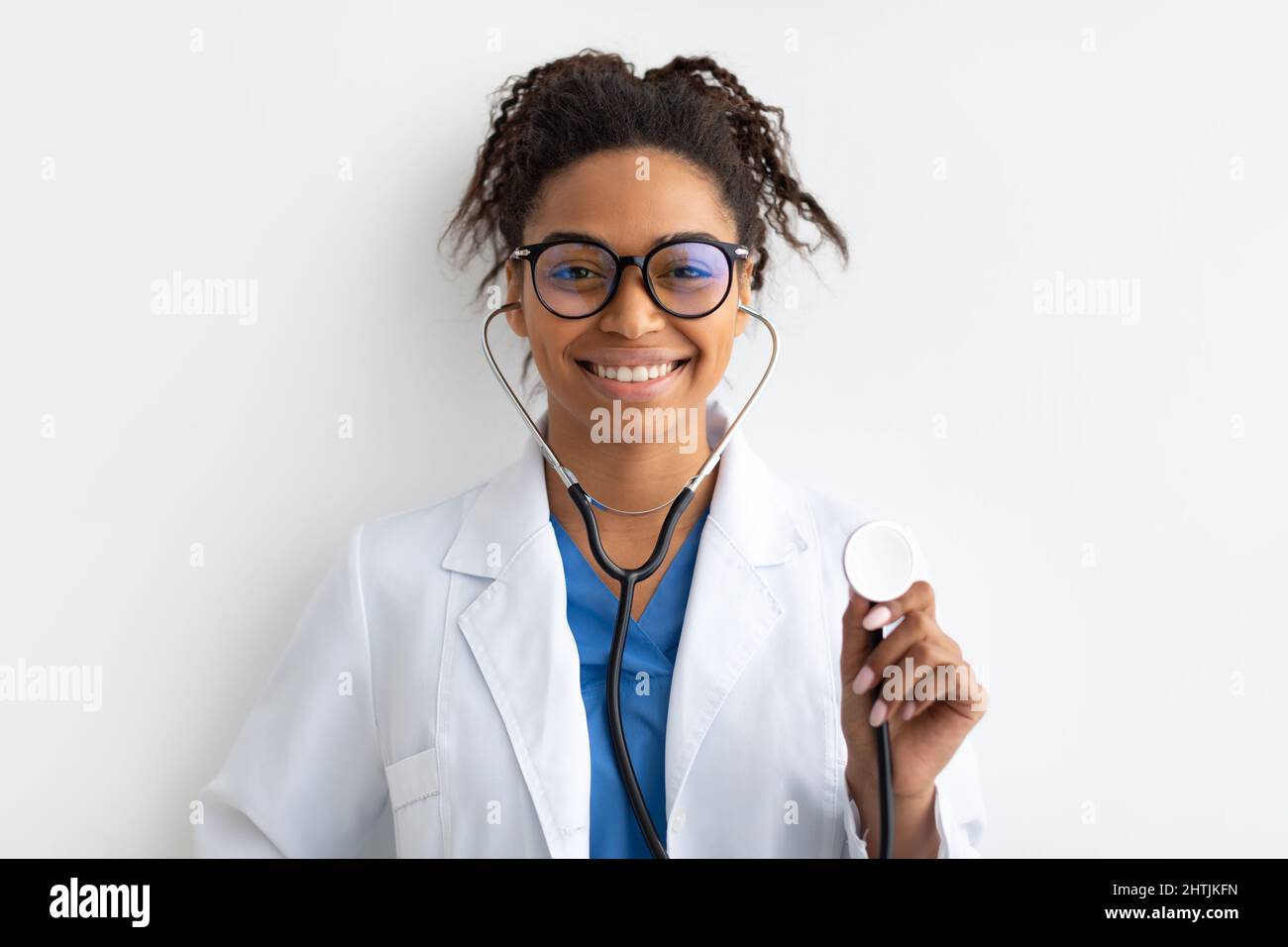 Portrait of black doctor smiling and showing stethoscope Stock Photo ...