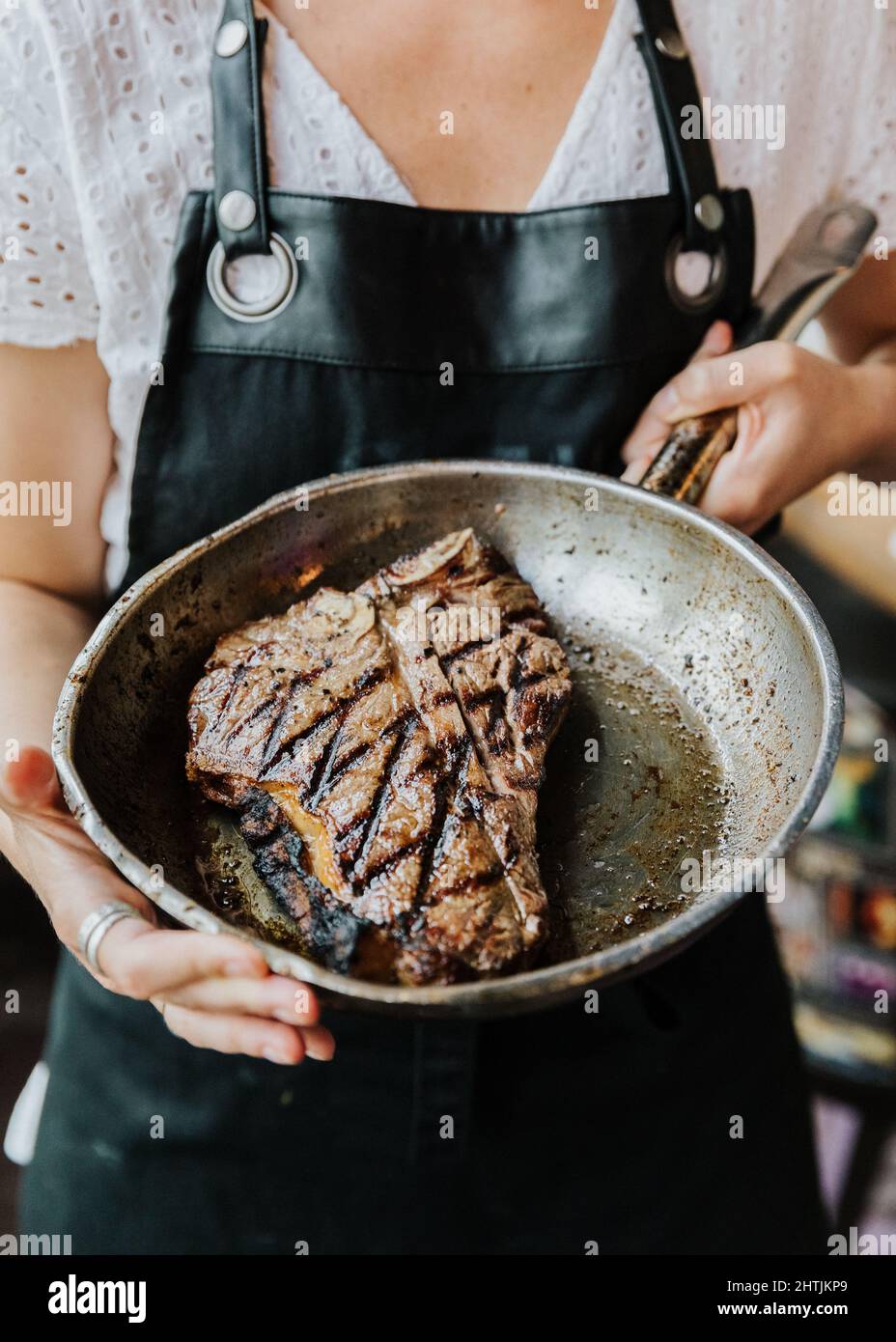 Vertical shot of a chef holding a pan with a steak Stock Photo - Alamy
