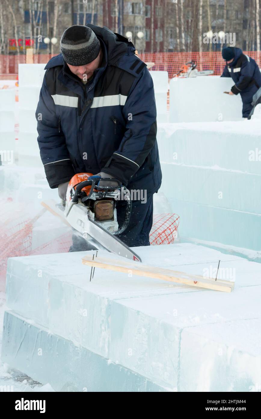 Construction worker saws an ice plate with a chainsaw Stock Photo - Alamy