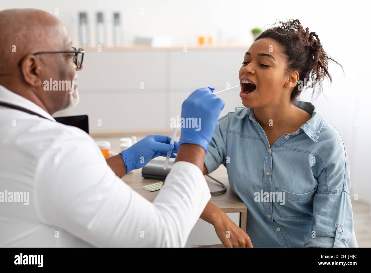 Doctor taking PCR test sample from potentially infected black woman ...