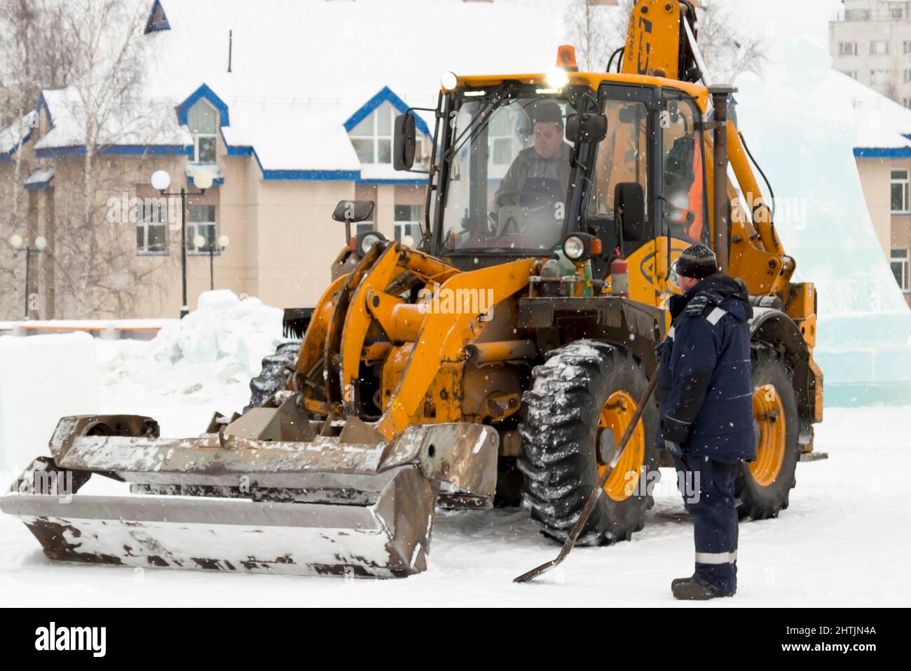 Construction worker clearing snow from the ice town Stock Photo - Alamy