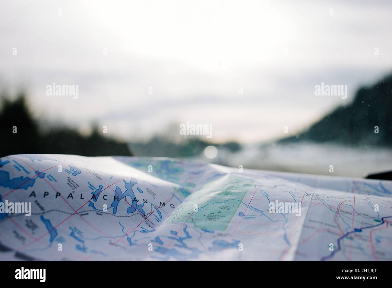 Paper map of the world on the dashboard of the car on a blurred ...