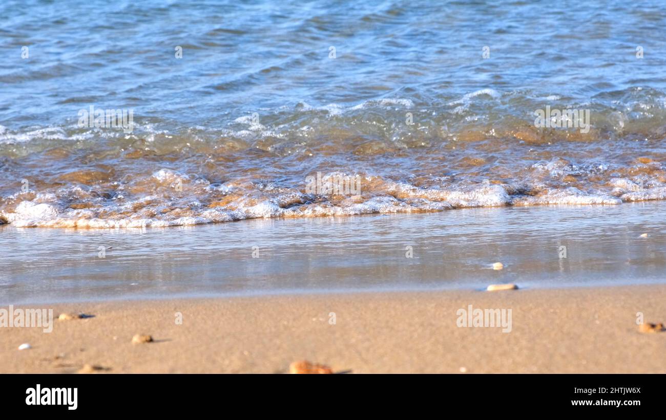 Soft wave of the blue sea on the sandy beach on a summer sunny day ...
