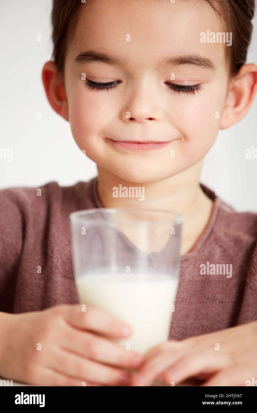 Mmmmmmmm milk. Cropped shot of a cute little girl looking happily at a ...
