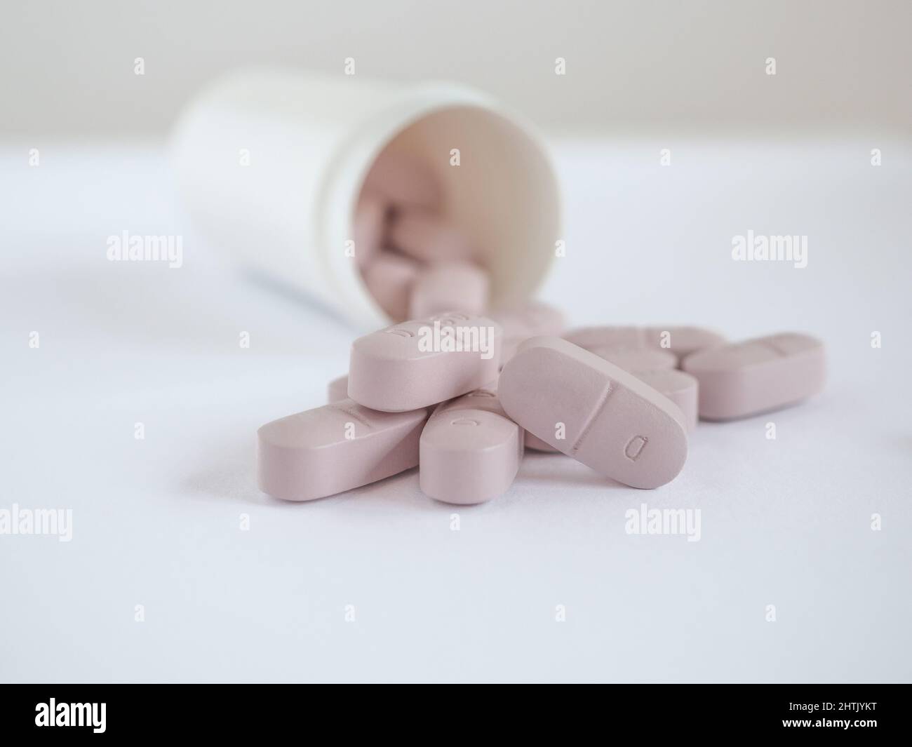 White dose of pink pills on white background. Healthcare concept. Copy ...
