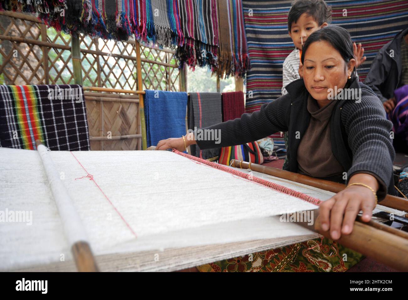 Dhaka, Bangladesh - January 11, 2013: An indigenous woman weaves sheets ...
